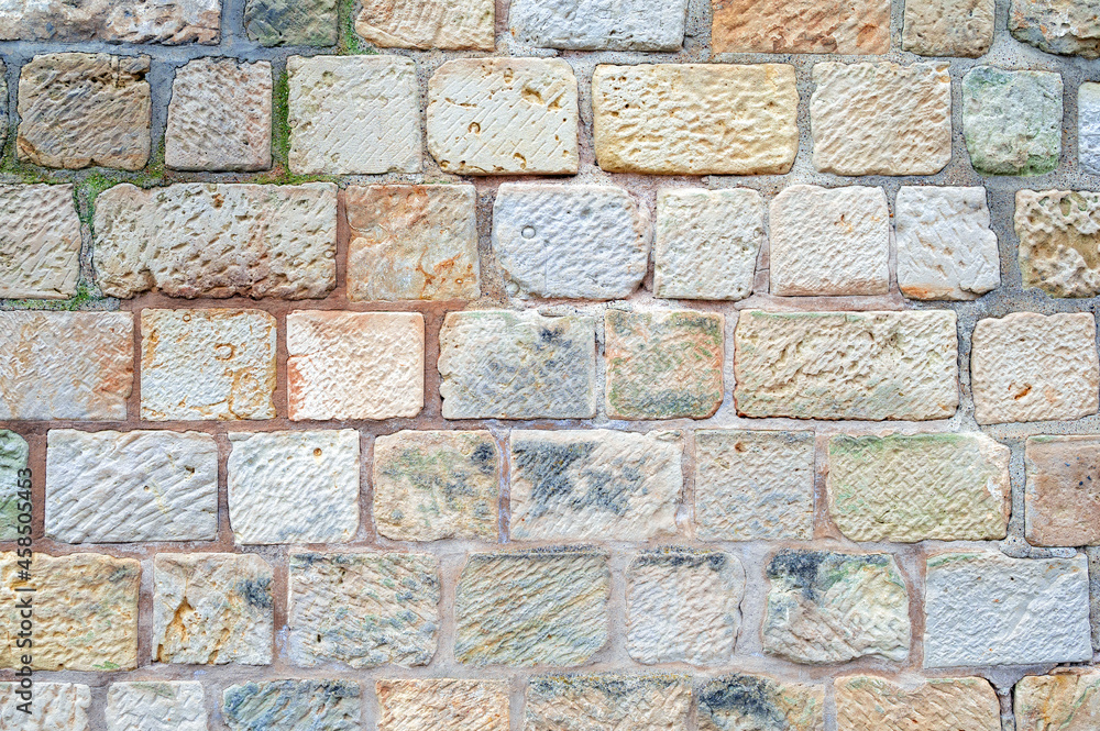 Historic facade of light stone. Wall background with different colored ...