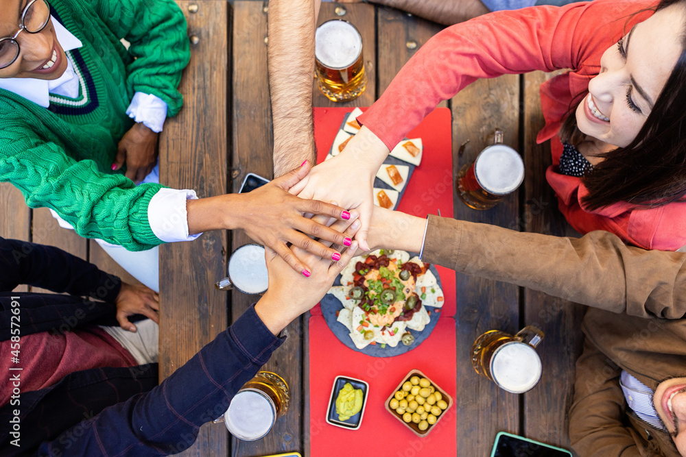 Millennial group of united friends stacking hands - Happy young ...