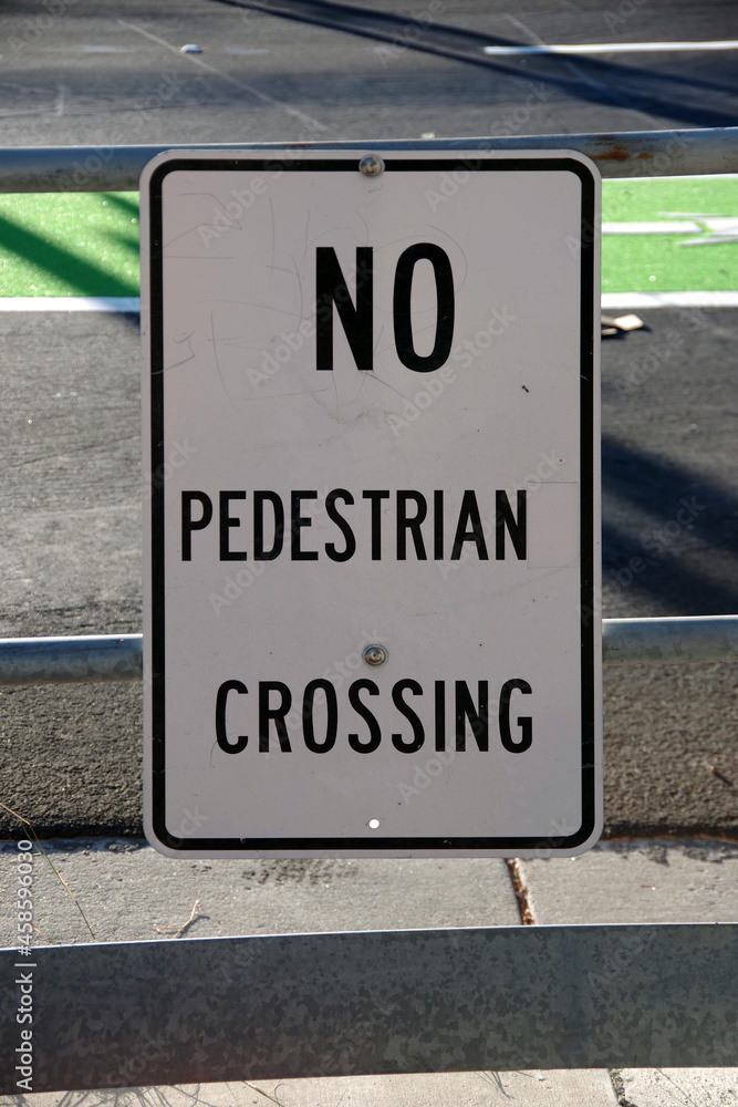 NO PEDESTRIAN CROSSING sign on a barrier along railroad tracks Stock ...