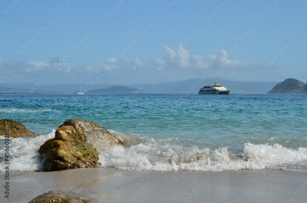 Ola rompiendo en roca con barco navegando al fondo Stock Photo | Adobe ...
