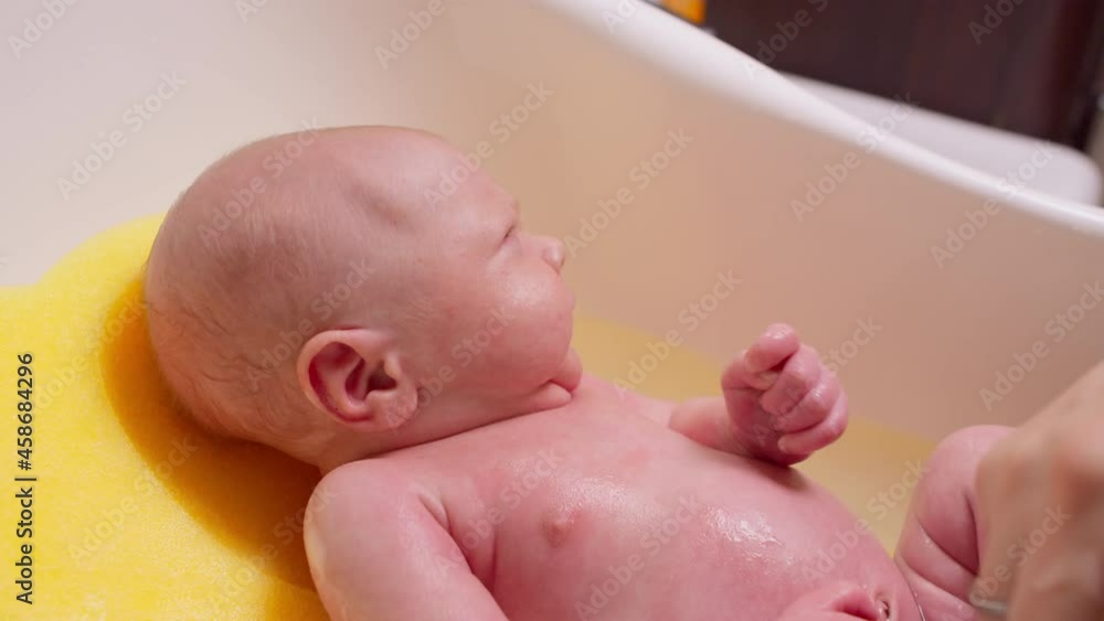 Mother bathing a small child in the bathtub. Bathing a newborn baby in ...