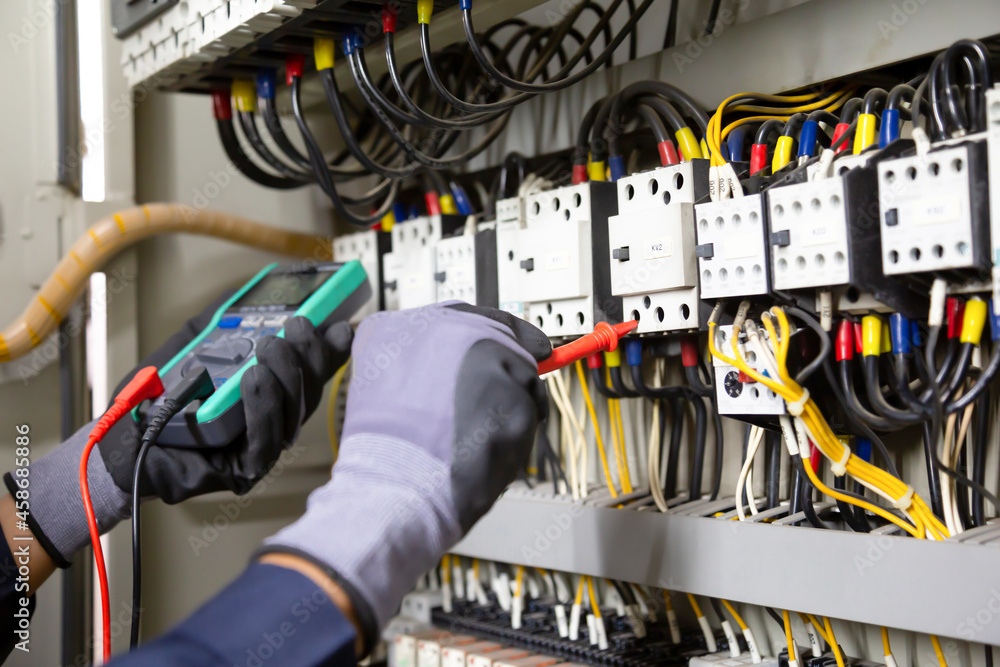 Electrician engineer tests electrical installations and wires on relay ...