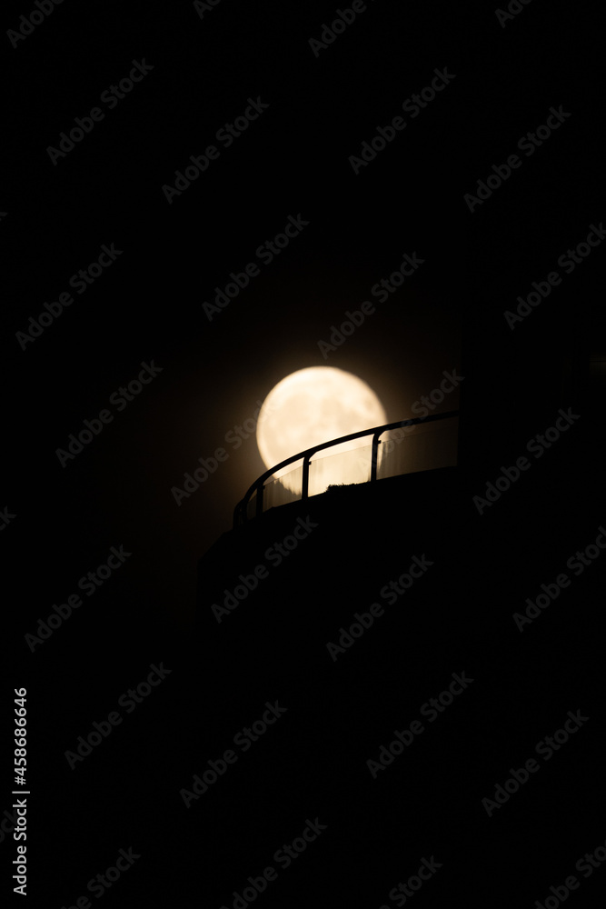 rooftop balcony railing with yellow full moon background Silhouettes ...