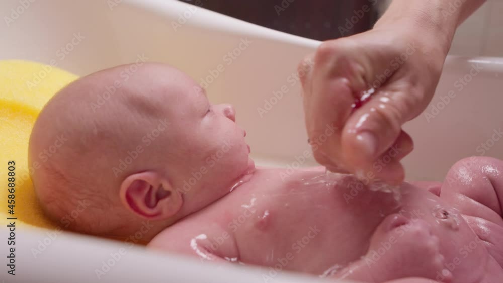 Hygiene of infants and care for newborns, bathing in a bath with warm ...
