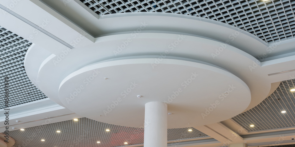 column in interior with suspended and grid ceiling with halogen spots ...