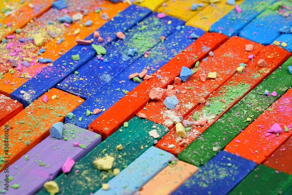 Bright chalks in a palette of rainbow colors and crumbs of colored ...