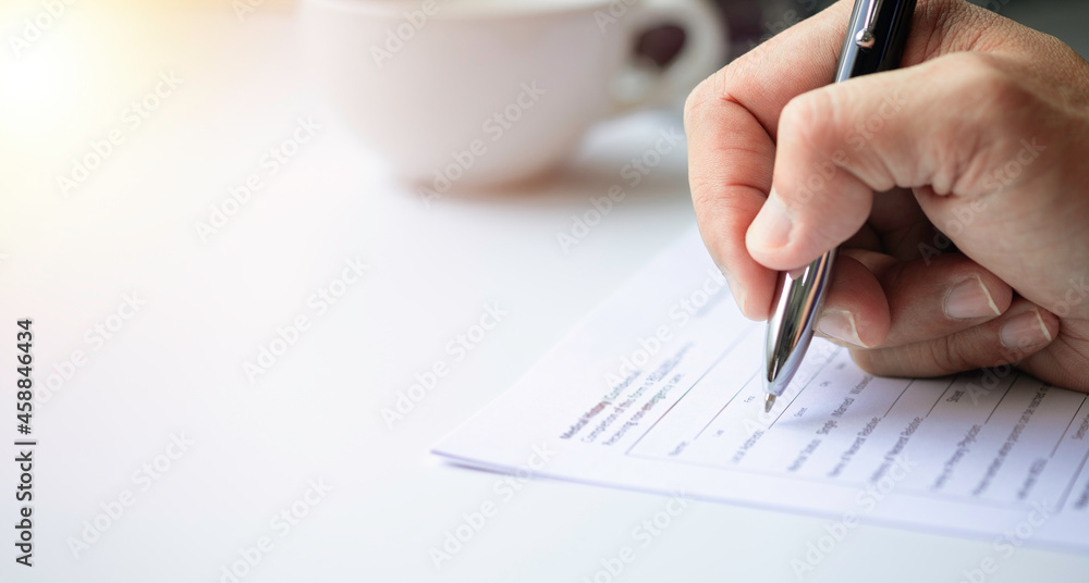 Close-up of Hand using writing pen with questionnaire or paperwork ...