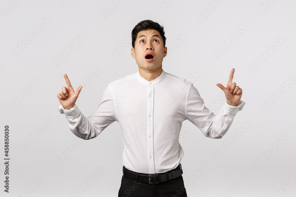 Shocked and scared worried asian businessman see something falling down ...