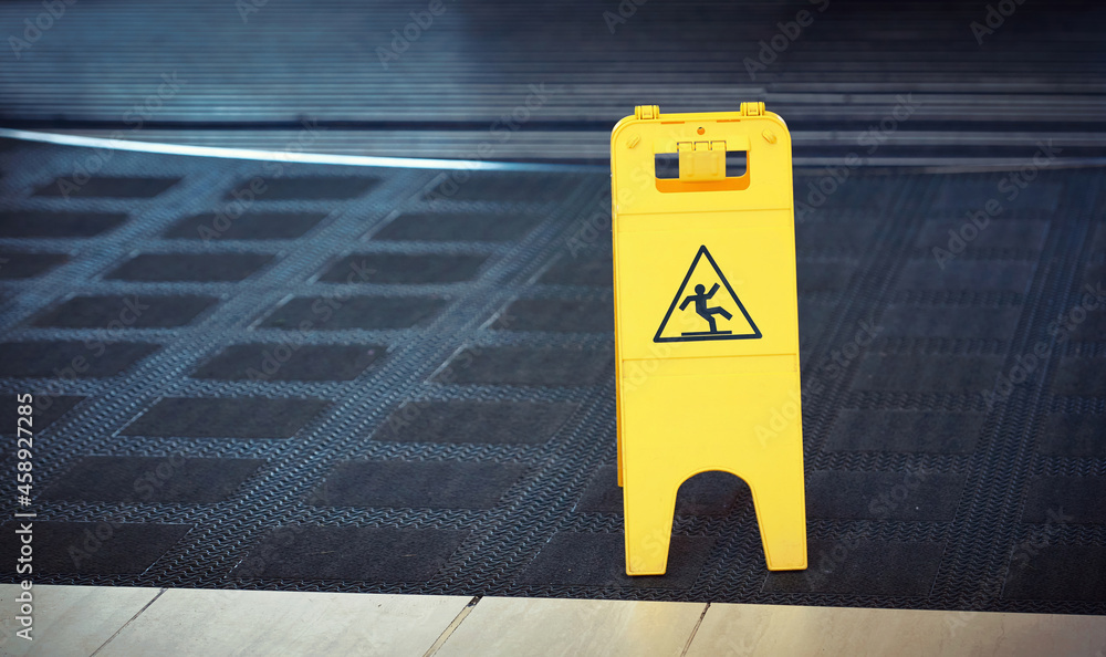 Wet floor sign standing in shopping mall. Yellow caution wet floor ...