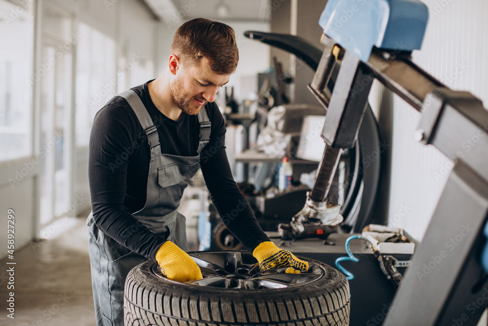 Car mechanic changing wheels in car Stock Photo | Adobe Stock