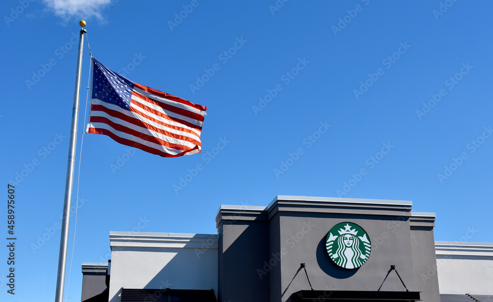American flag in front of a Starbucks Coffee Building Stock Photo ...