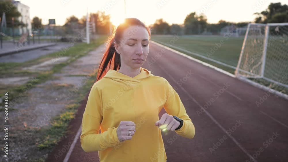 Concept healthy running. Young fitness woman running at the stadium ...