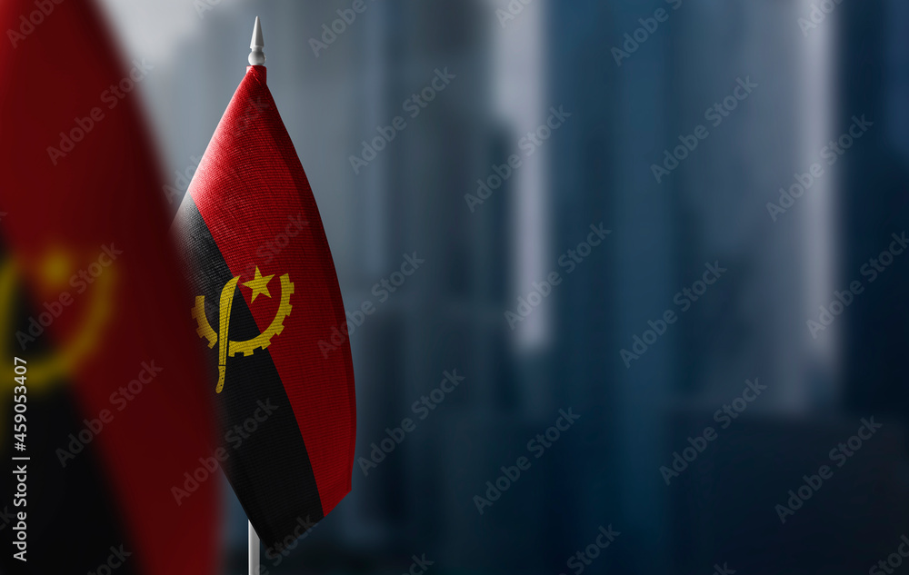 Small flags of Angola on a blurry background of the city Stock Photo ...