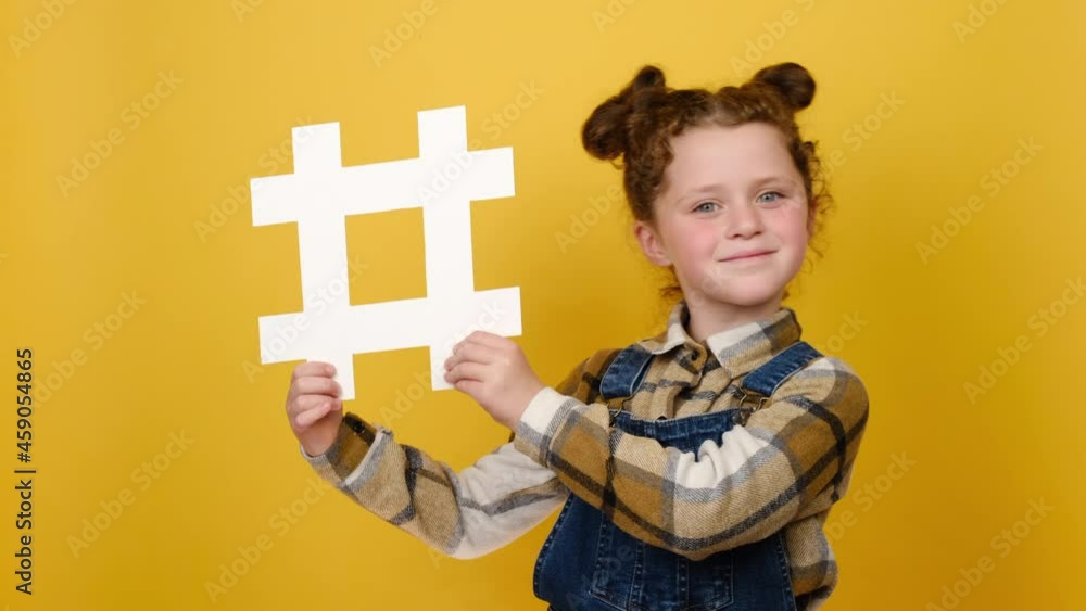 Video Stock Portrait of cute adorable kid girl holding white hashtag ...
