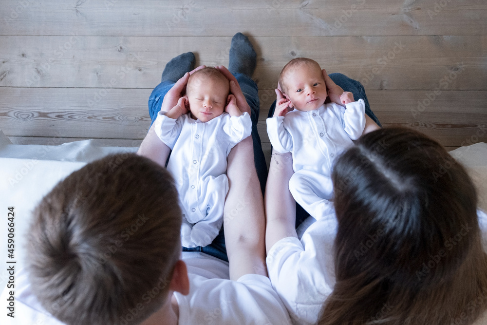 Newborn Identical twins on the bed, on a parents hands. Life style ...