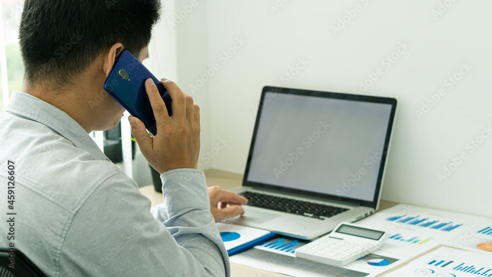back view of a businessman talking on the phone in the office ...
