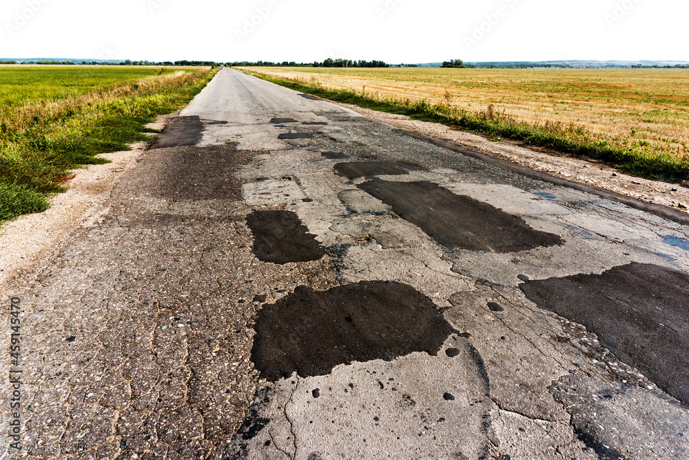 Poor repair of the road surface on a suburban highway. Bitumen patches ...