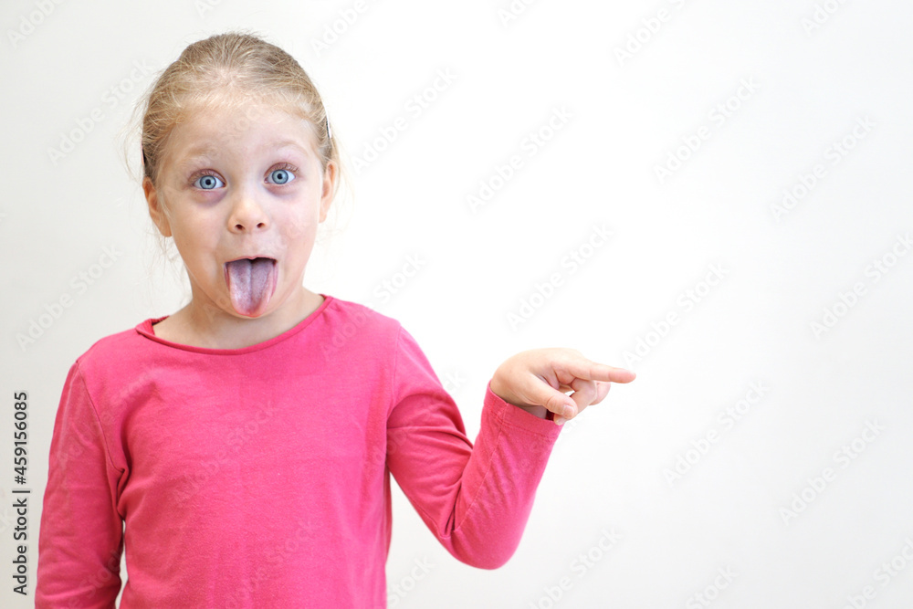 A cheerful little girl attracts attention with her emotions. Pointing ...