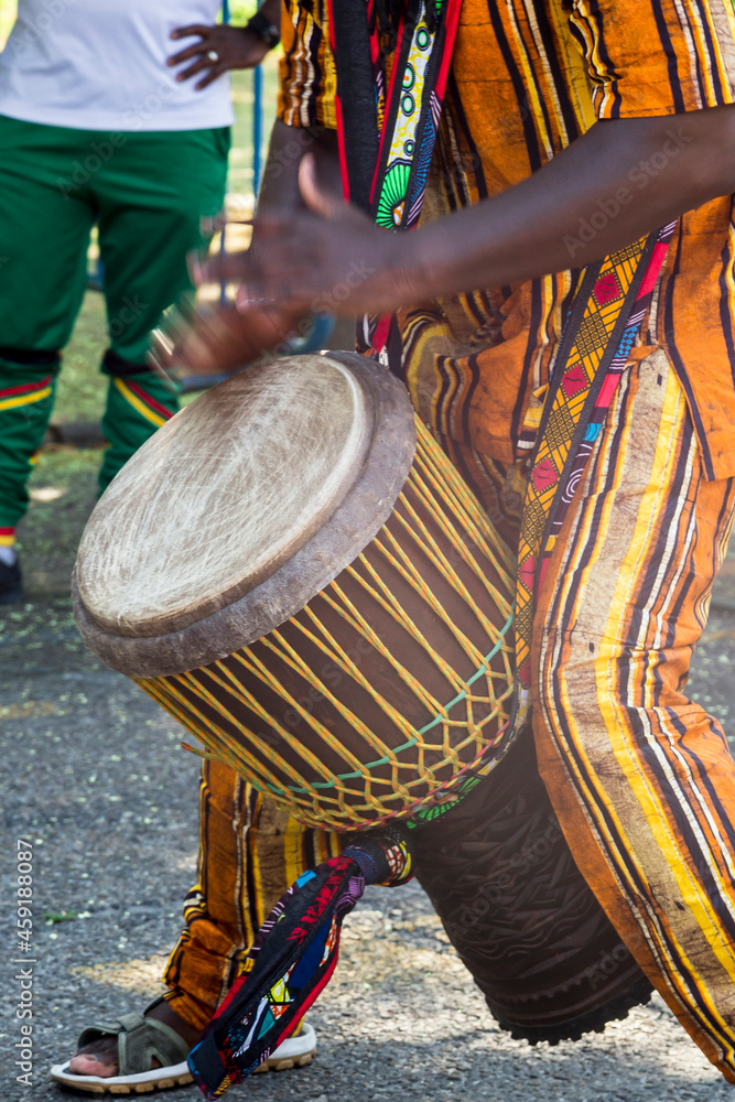 African in traditional costume playing drum. Hand movement. African ...