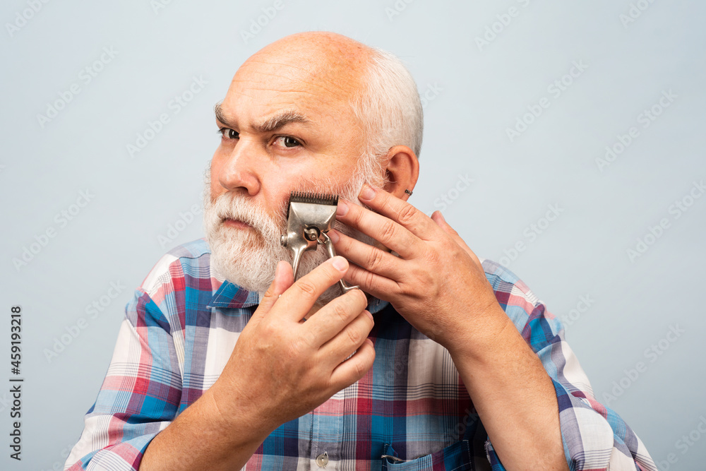 Old gray man cut bear with hair clipper. Portrait of barber hold old ...
