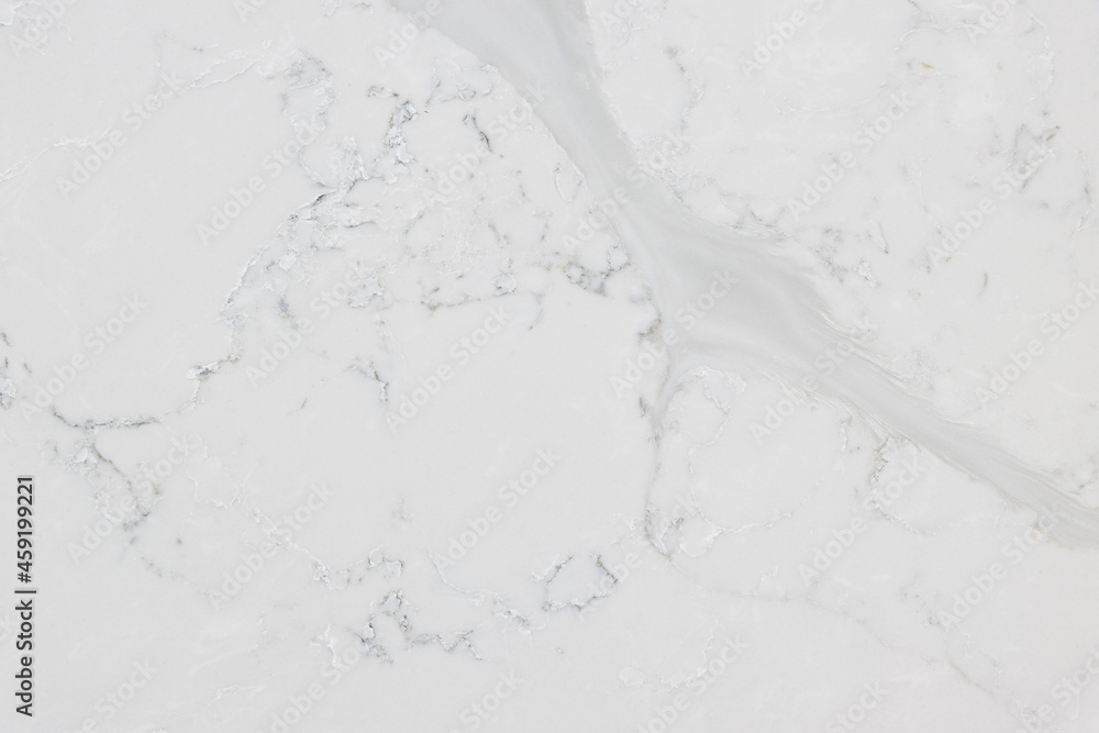 Detail of a quartz slab that has an off-white background with soft ...