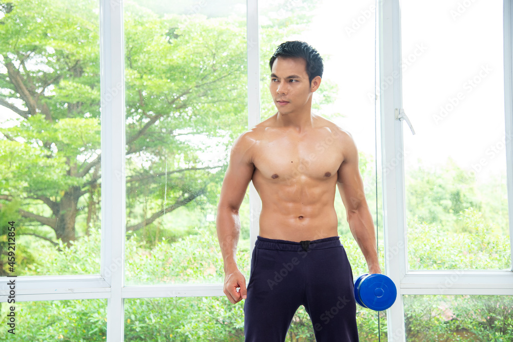 Strong well built bodybuilder lifting dumbbell weights getting ready ...