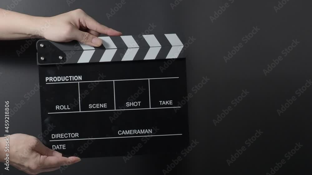 Movie slate or clapperboard hitting. Close up hand holding empty film ...