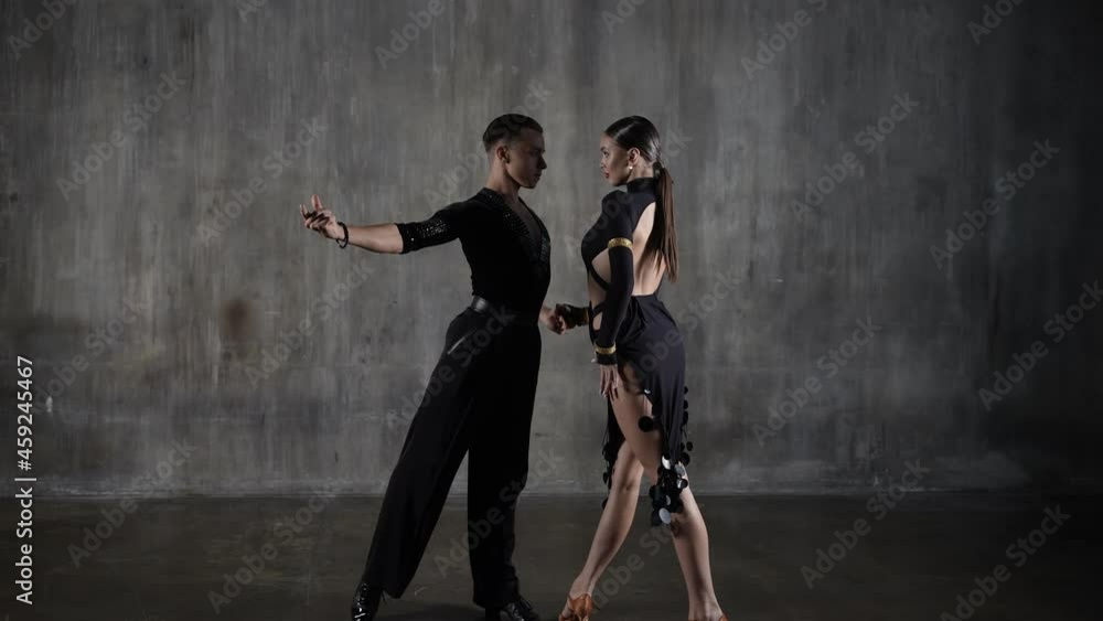The young active millennial dance ballroom couple in black dress ...