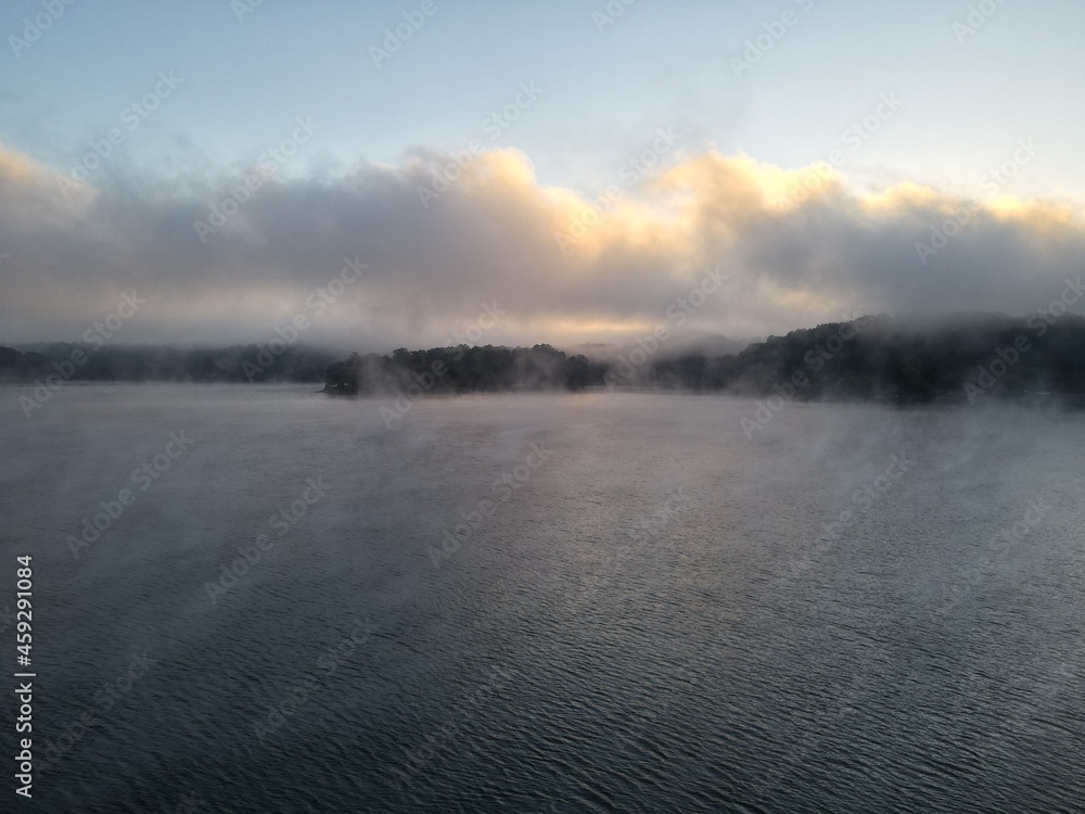 Fog and steam coming from a body of water due to cool morning sunrises ...