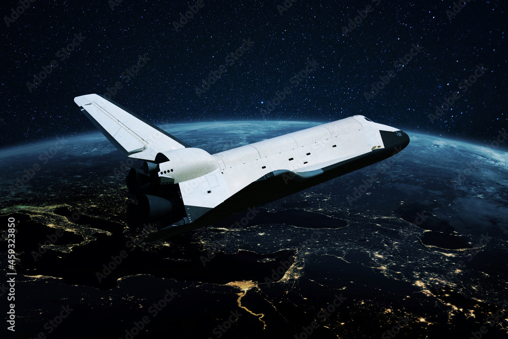 Foto de Space shuttle rocket flies in open space over the night planet ...
