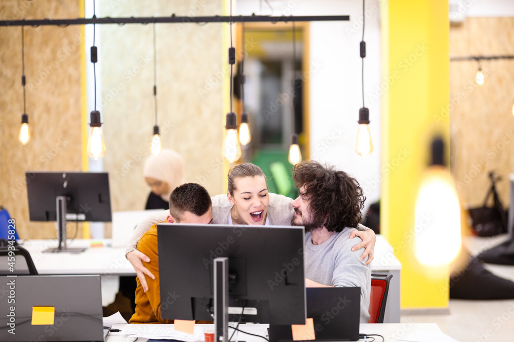 Three caucasian colleagues cheering for job well done in a modern ...
