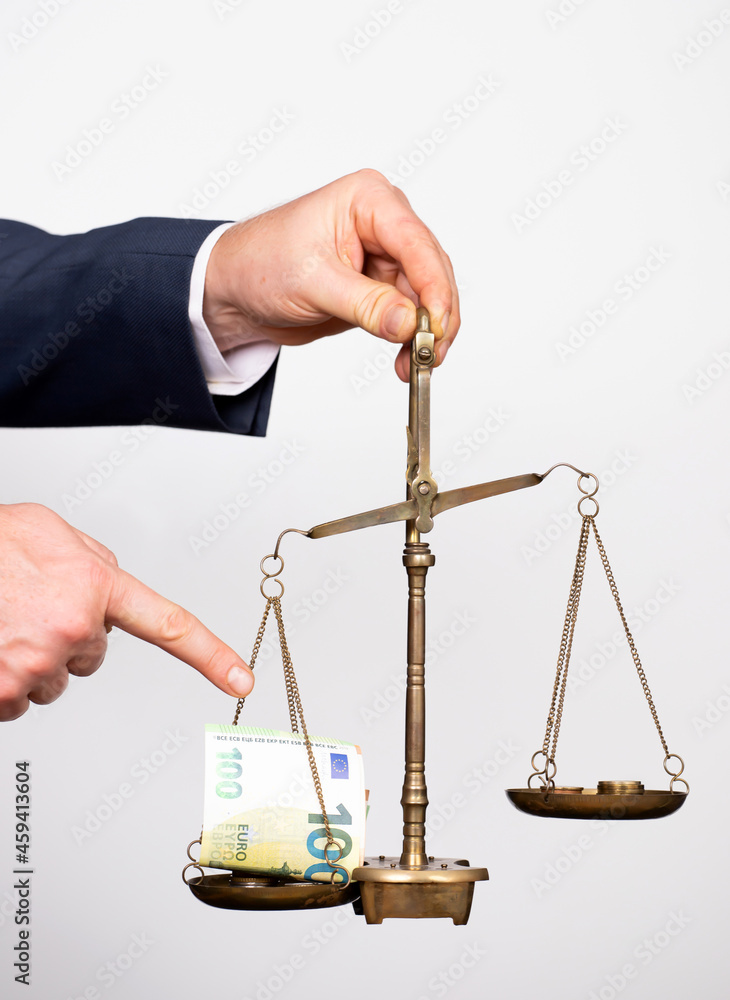 Money weighing on justice scale in business man hand. Payment balance ...