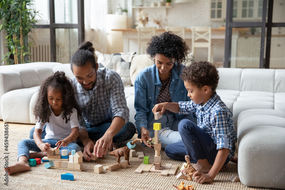 Foto de Loving African American parents with two kids playing with ...