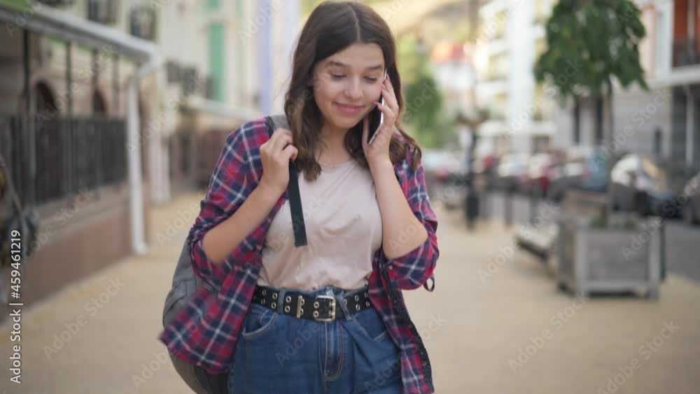 Vidéo Stock Front view of charming confident Caucasian teenage girl talking on phone smiling ...