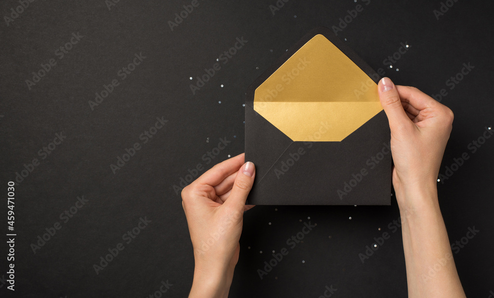 First person top view photo of female hands holding black and golden ...