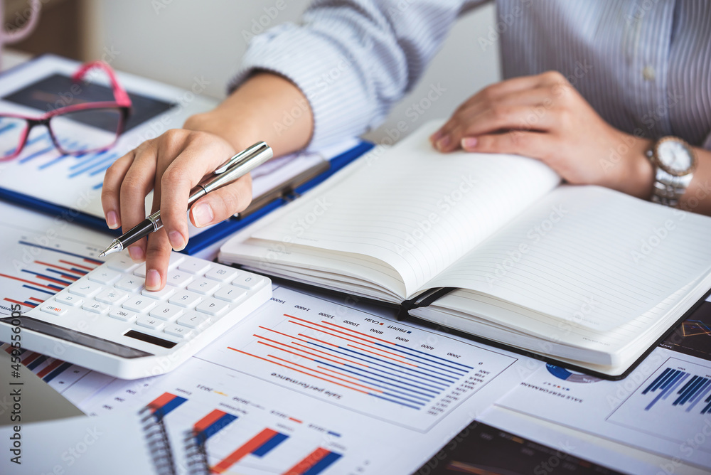 business woman or accountant who are using a calculator to calculate ...