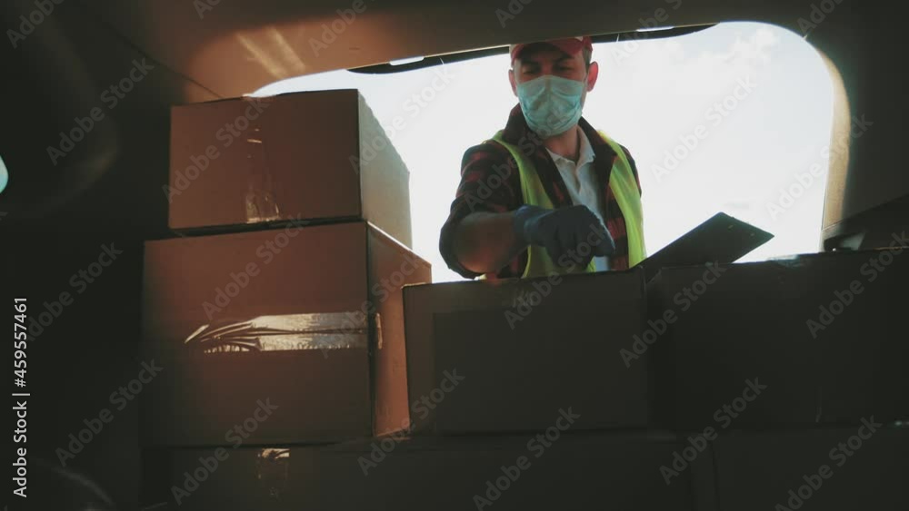Delivery service. Delivery man in a protective mask and gloves near a ...