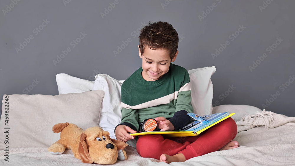 Cute little boy reading alphabet book. Child looks at open book ...