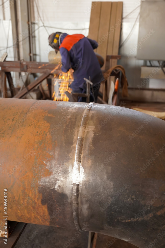 Butt weld. A welding specialist welds a seam of a pipeline for an oil ...