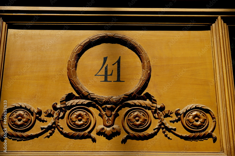 Numéro 41 dans un cercle de bois ouvragé. Façade en bois. Numéro de rue ...