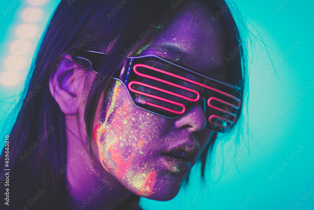 Beautiful young woman dancing and making party with fluorescent ...