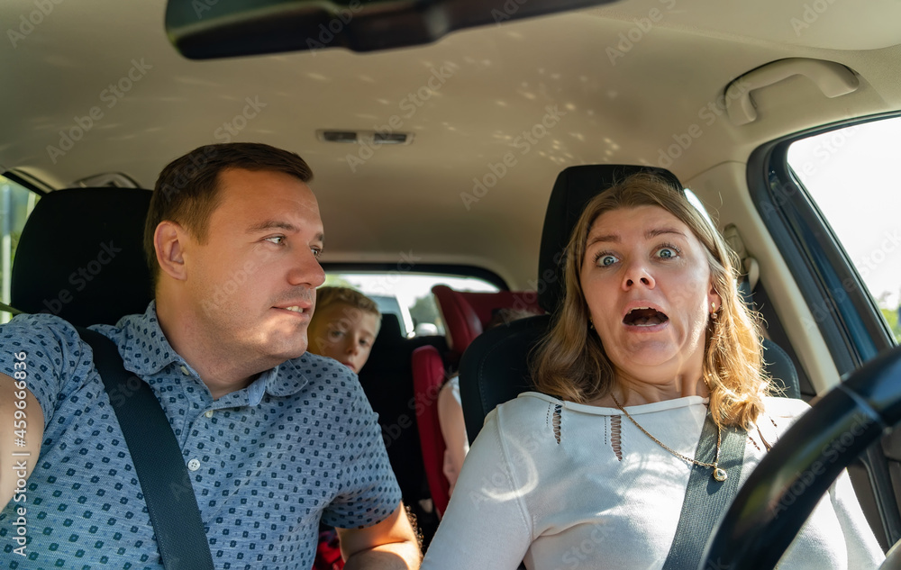 Front portrait of scared woman driving car and happy man. Shock ...