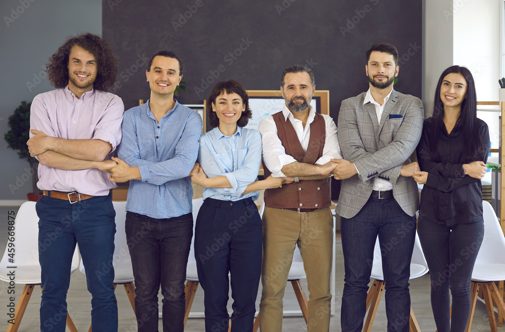 Young smiling office colleagues hold hands in a chain, happy colleagues ...