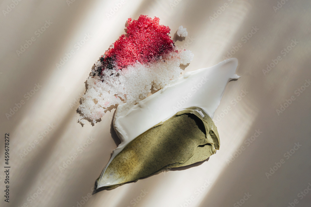 Various cosmetic mask, creams, serum, scrub and lotion smear on a beige ...