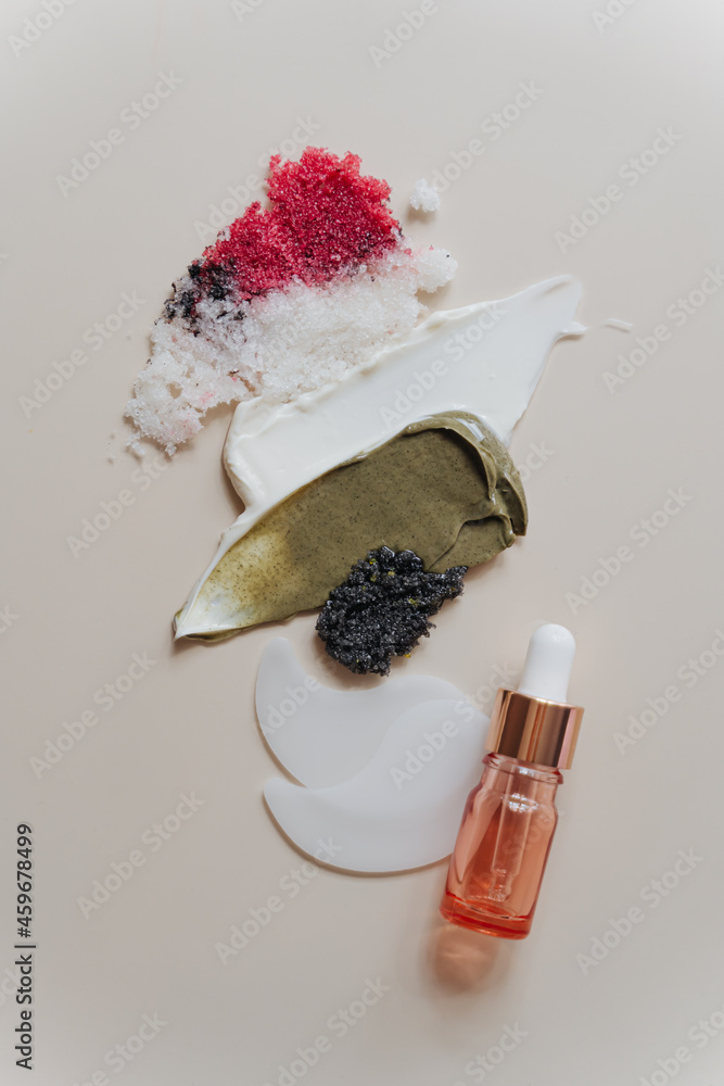 Various cosmetic mask, creams, serum, scrub and lotion smear on a beige ...