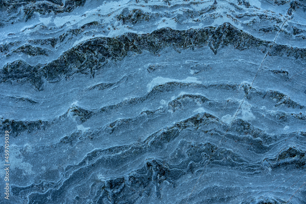 Natural rock texture of air and water eroded blue rock wall in a beach ...