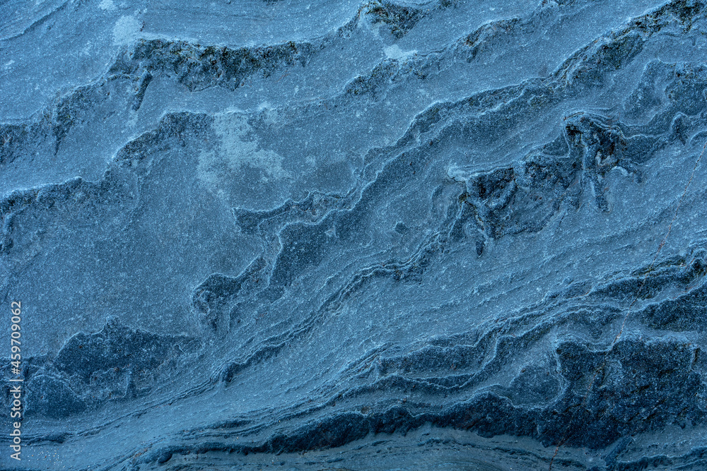 Natural rock texture of air and water eroded blue rock wall in a beach ...