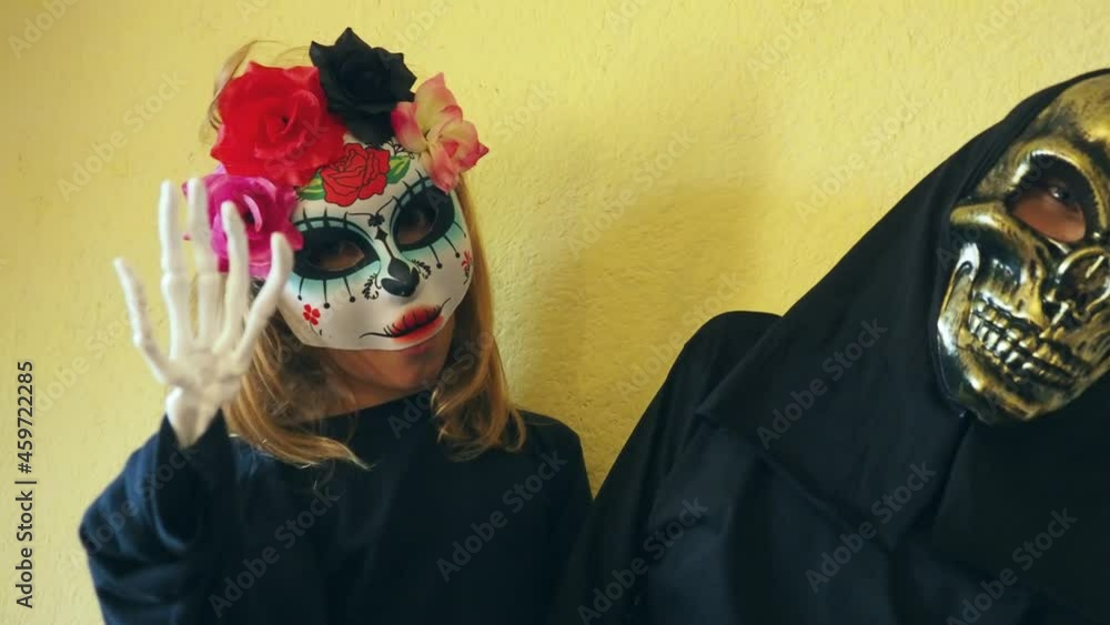 Children dressed in black costumes and scary Halloween masks. Girl in a ...