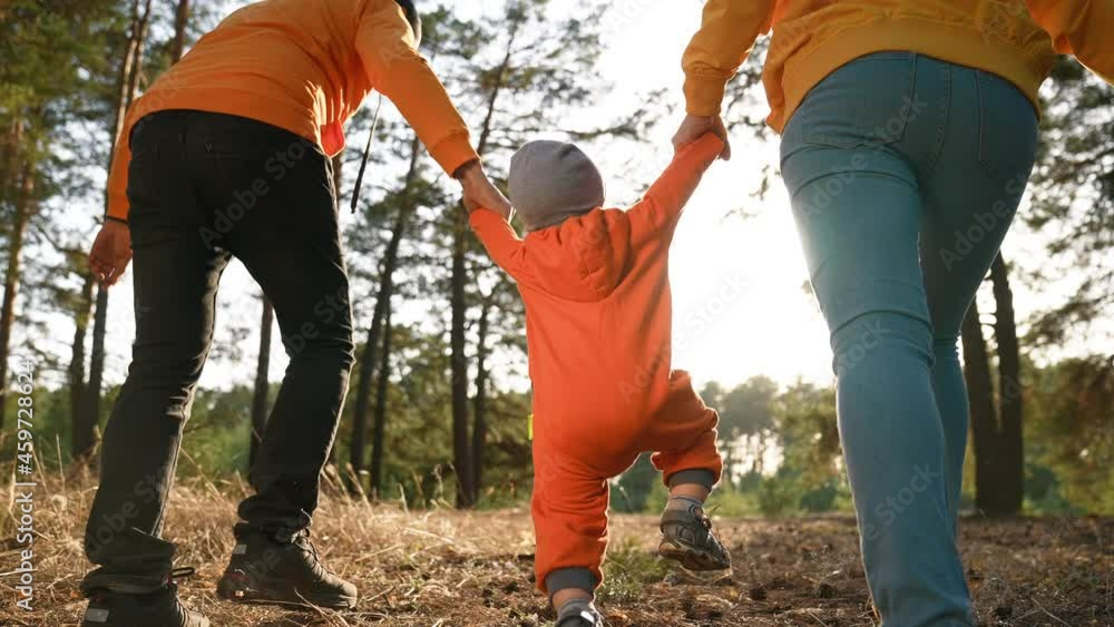 happy family. parents run with baby throw him up holding hands ...