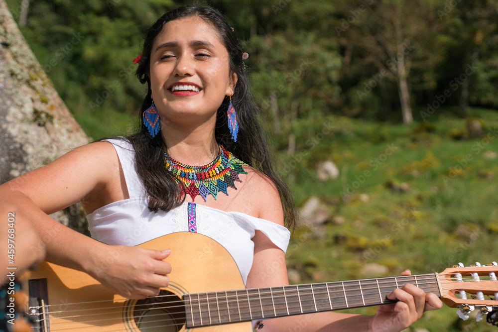 Woman playing instrument outdoors. music in nature, under a tree ...